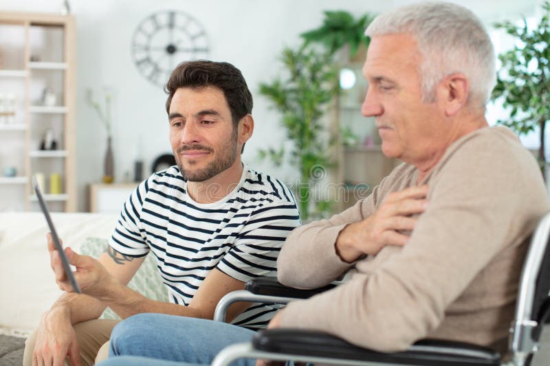 Smiling Man Taking Care about Eldery Father in Wheelchair Stock Photo ...