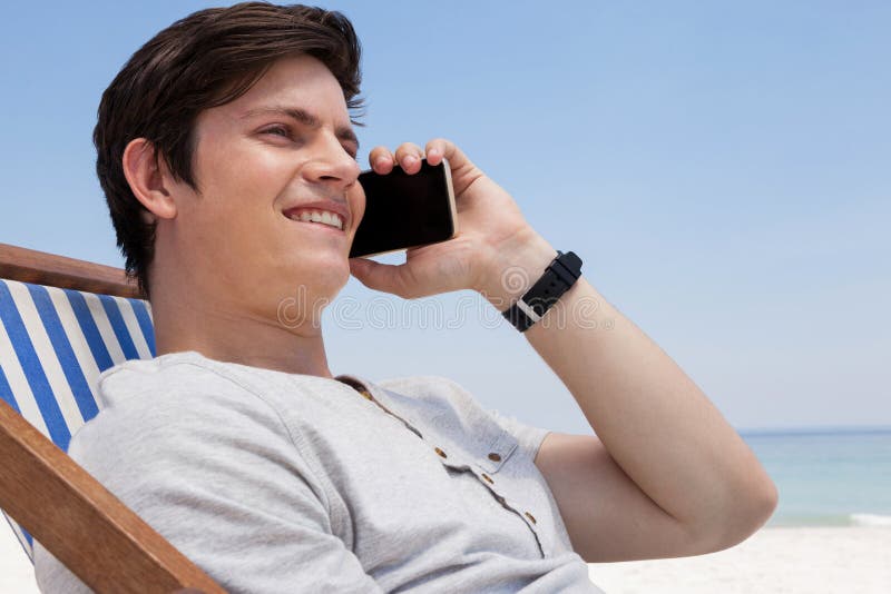 Smiling Man Talking on Mobile Phone at Beach Stock Photo - Image of ...