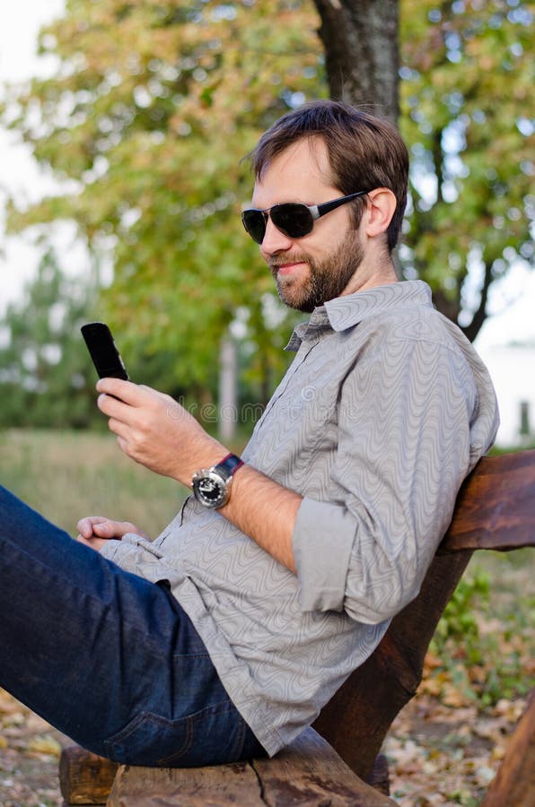 Smiling man texting stock photo. Image of bench, reading - 29561034