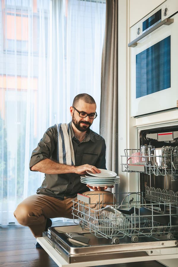 Smiling Man Unloading Dishwasher Stock Photo - Image of plates, routine ...