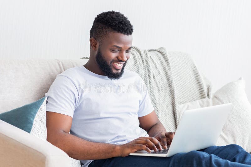 Smiling Man Using Laptop while Sitting on Couch Stock Image - Image of ...