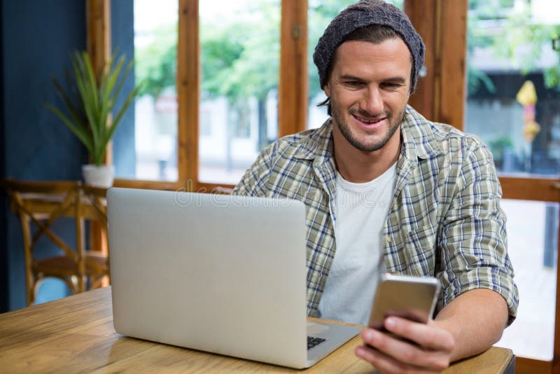 Smiling Man Using Mobile Phone and Laptop in Coffee Shop Stock Image ...