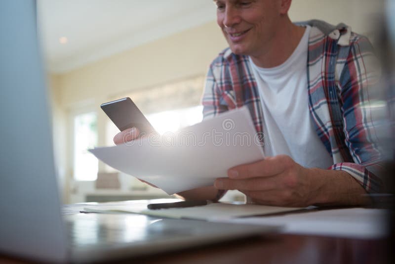 Man Using Mobile Phone and Looking at Document Stock Image - Image of ...