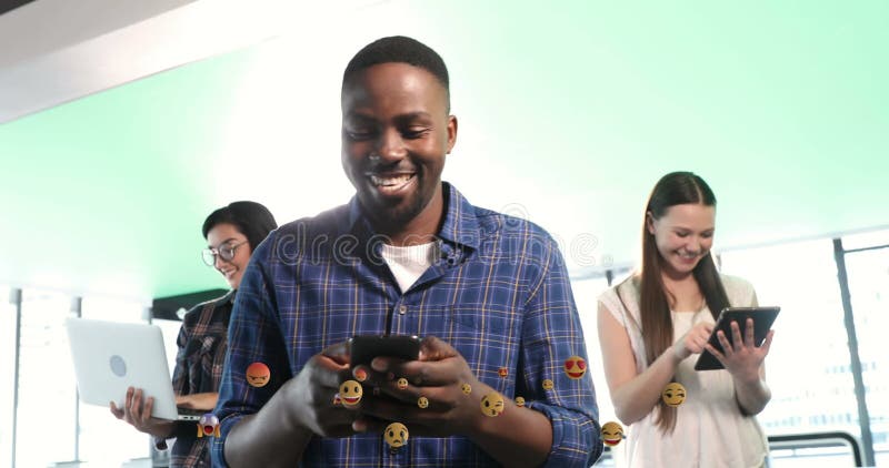 Smiling Man Using Smartphone with Emojis, Colleagues Working on Digital ...