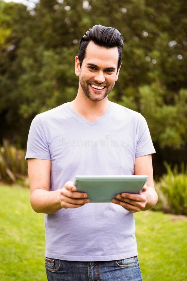 Smiling man using tablet stock image. Image of handsome - 66094589