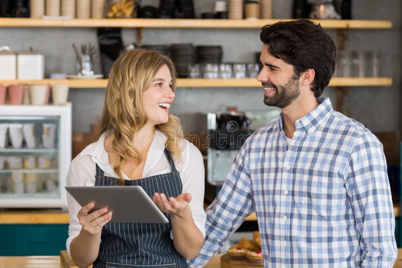 Smiling Man and Waitress Standing at Counter Using Digital Tablet Stock ...