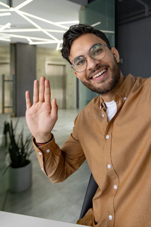 Smiling Man Waving during Video Call in Modern Office Environment Stock ...