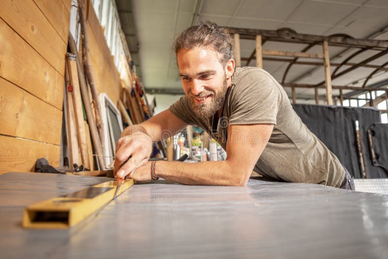 Smiling Man Working with a Cutter Knife on a Workbench Stock Photo ...