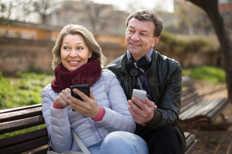 Smiling Mature Couple Exchanging Phone Numbers Stock Image - Image of ...