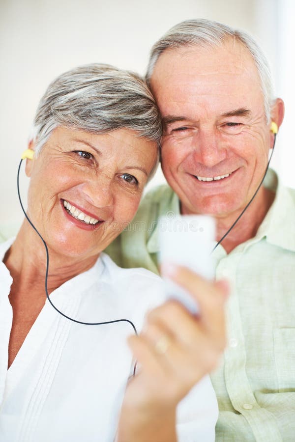 Smiling Mature Couple Listening Music Together. Closeup of Smiling ... Smiling Mature Couple Listening Music Together. Closeup of Smiling ...