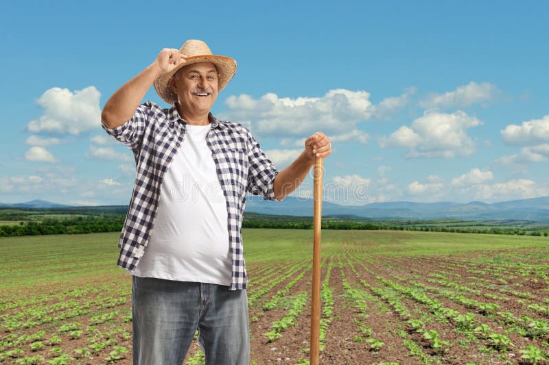 Smiling Mature Farmer Posing on a Field and Greeting with His Hat Stock ...