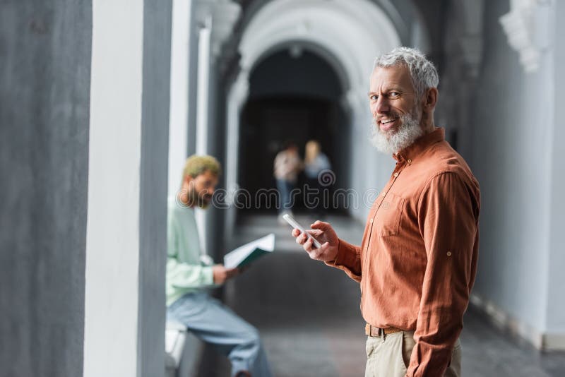 Smiling Mature Professor Using Smartphone and Stock Image - Image of ...