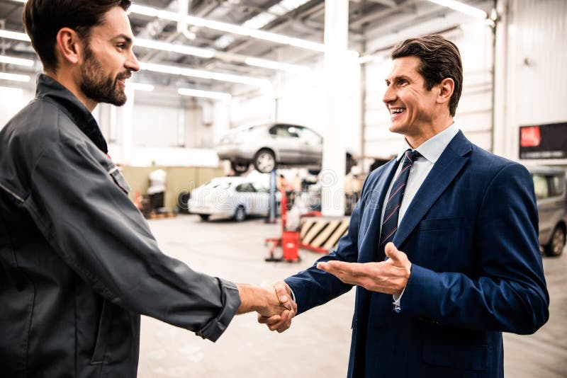 Smiling Mechanic and His Customer Shaking Hands Stock Photo - Image of ...