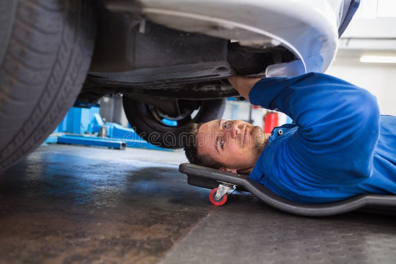 Smiling Mechanic Lying on Trolley Stock Image - Image of lying, male ...