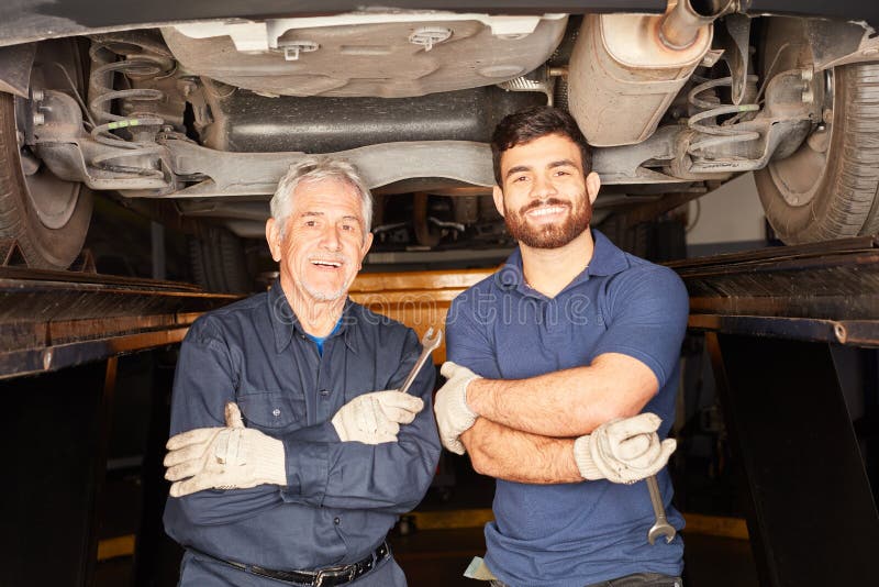 Smiling Mechanic Team with Master and Trainee Stock Photo - Image of ...