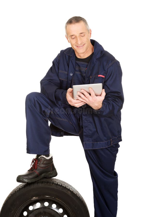 Smiling Mechanic with a Tire and Tablet Stock Photo - Image of studio ...