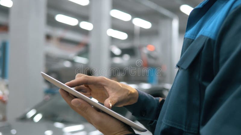 Smiling Mechanic Using a Tablet Pc at the Repair Garage Service Stock ...