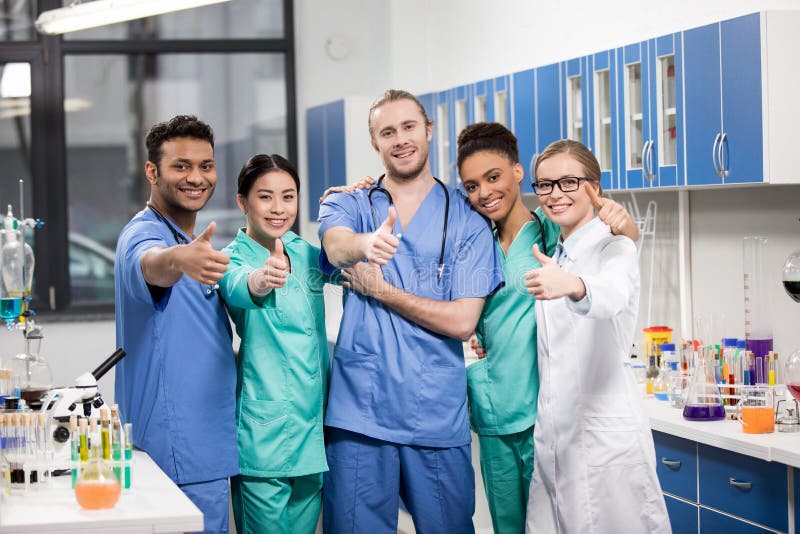 Smiling Medical Workers Showing Thumbs Up in Laboratory Stock Photo ...
