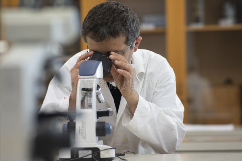 Smiling Microbiologist at Work into Laboratory Using a Microscope Stock ...