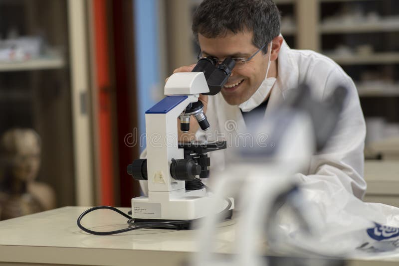 Smiling Microbiologist at Work into Laboratory Using a Microscope Stock ...