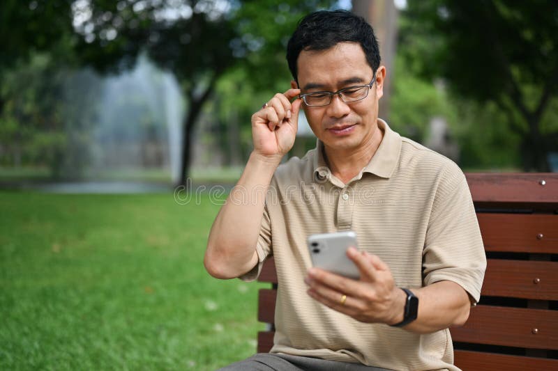 Smiling Middle Age Man Wearing Glasses Using Mobile Phone in the Public ...