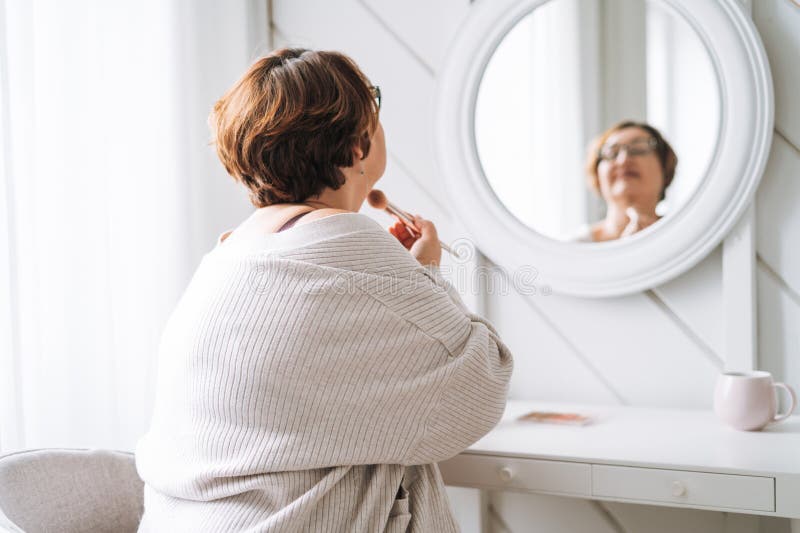 Smiling Middle Aged Plus Size Woman Doing Makeup Near Mirror at Home ...