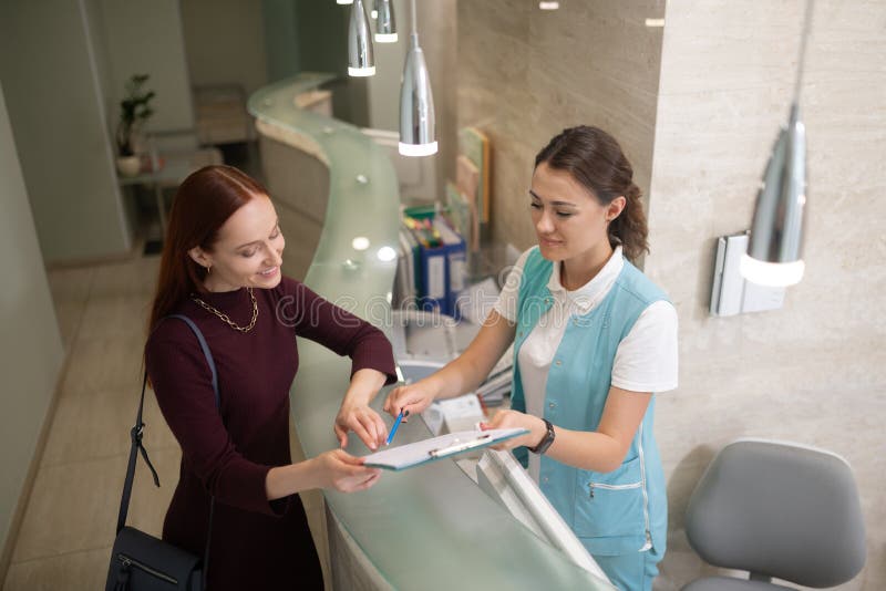 Helpful Receptionist Wearing Uniform Speaking with Client Stock Image ...