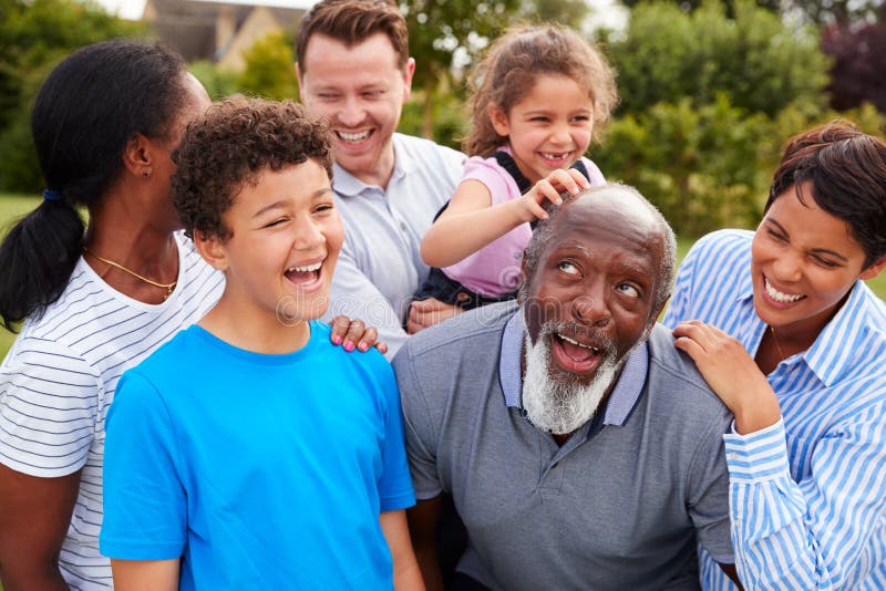 Father Serving As Multi-Generation Mixed Race Family Eat Meal Around ...