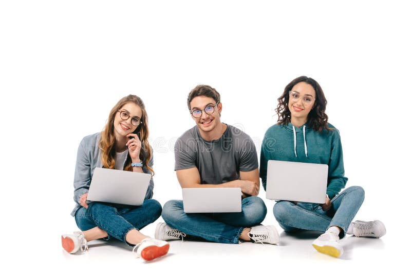 Smiling Multicultural Students Sitting with Laptops and Looking at ...