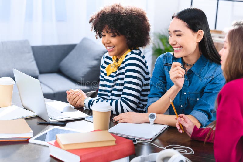 Smiling Multicultural Students Using Laptop while Stock Image - Image ...