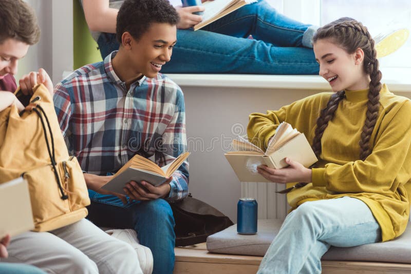 Smiling Multiethnic Schoolchildren Reading Books during Stock Image ...