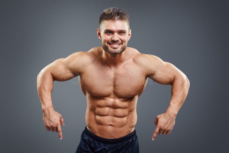 Smiling Muscular Man Pointing Down Stock Photo - Image of success ...