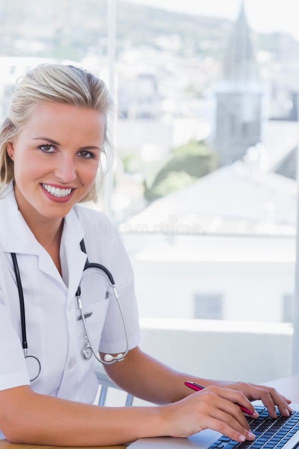 Smiling Nurse Working on Her Laptop Stock Photo - Image of fair ...