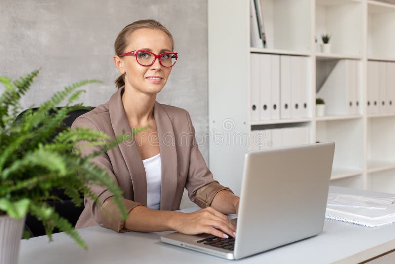 Smiling Office Worker Sits in Chair Behind Laptop Stock Image - Image ...