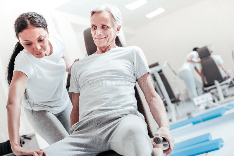 Smiling Old Man Exercising and a Trainer Helping Him Stock Image ...