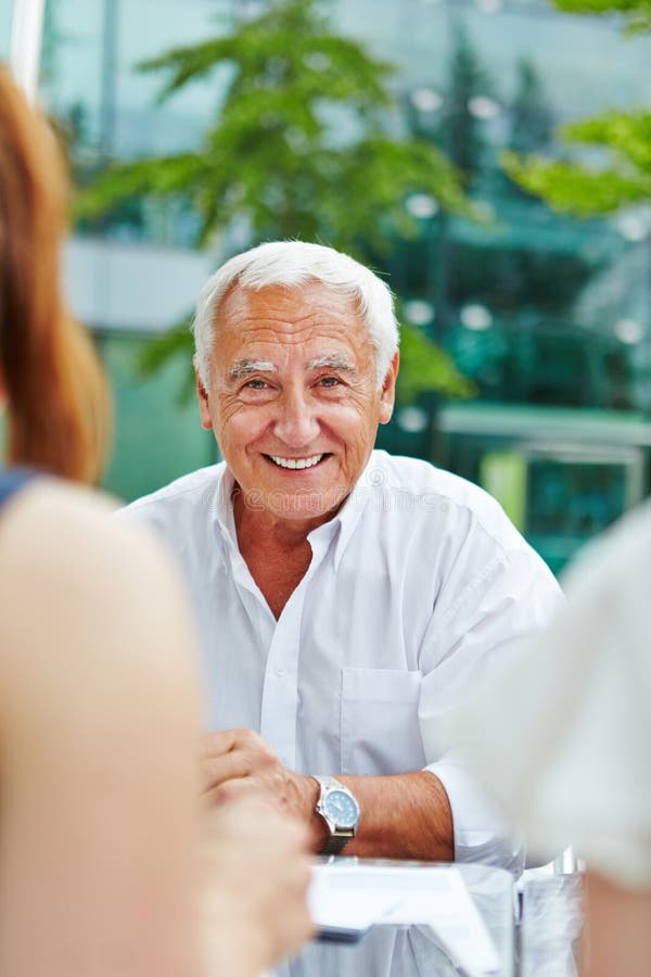 Smiling Old Manager Sitting on Table Stock Photo - Image of ...