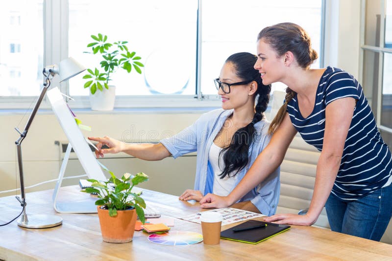 Smiling Partners Working Together with Photographs on Computer Stock ...