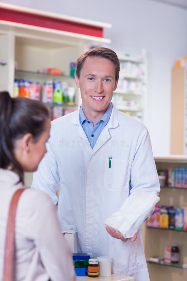Smiling Pharmacist Holding a Paper Bag Looking at Camera Stock Photo ...