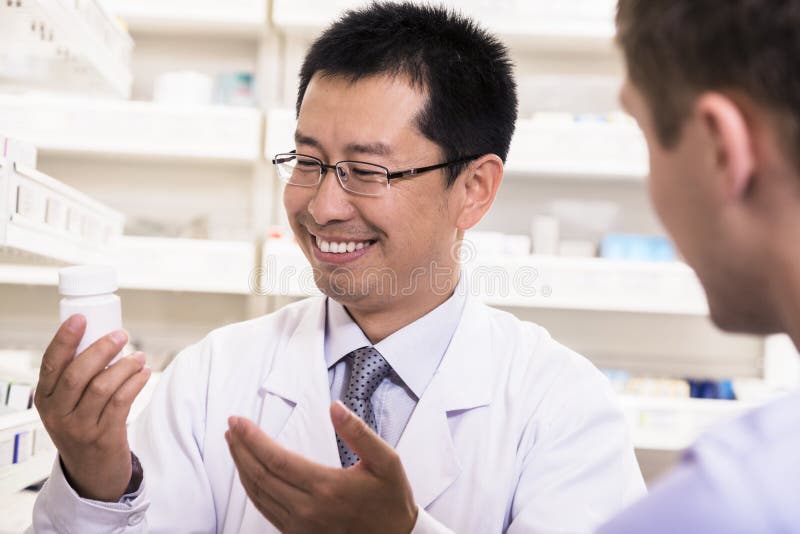 Smiling Pharmacist Showing Prescription Medication To a Customer Stock ...