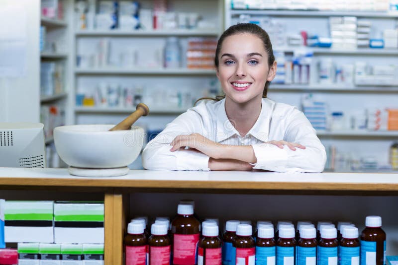 Smiling Pharmacist Sitting at Counter in Pharmacy Stock Photo - Image ...