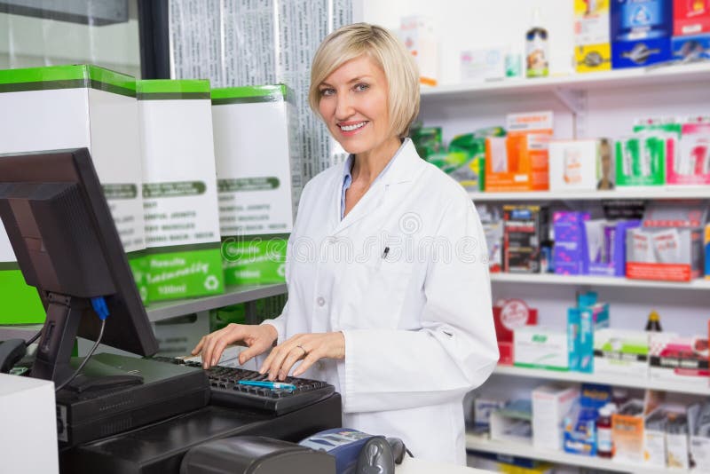 Smiling Pharmacist Using Computer Stock Photo - Image of medicament ...