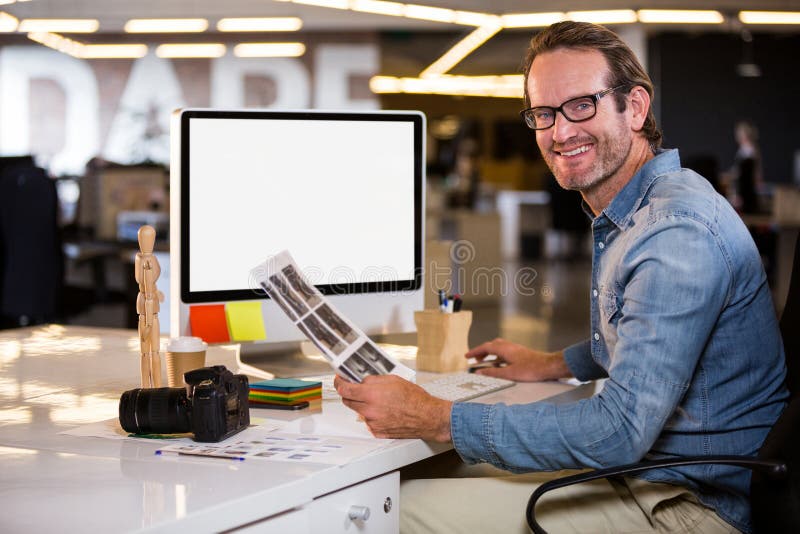 Smiling Photo Editor Sitting at Computer Desk Stock Image - Image of ...