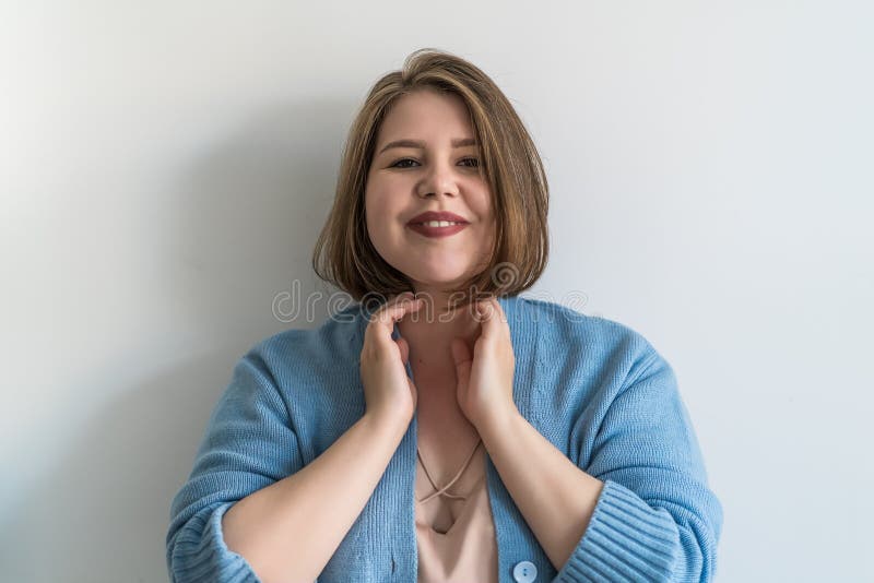 Smiling Plus-size Woman Touching Her Neck, Expressing Confidence and ...
