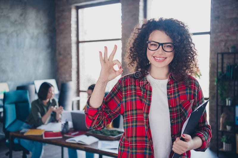 Smiling Professional Displays Okay Gesture in Cozy Office Setting ...