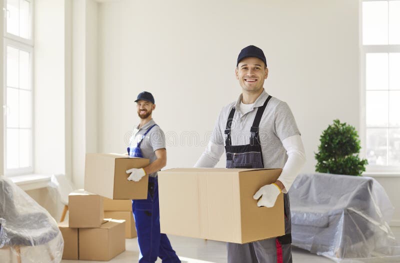 Smiling Professional Movers Carrying Cardboard Boxes and Assisting in ...