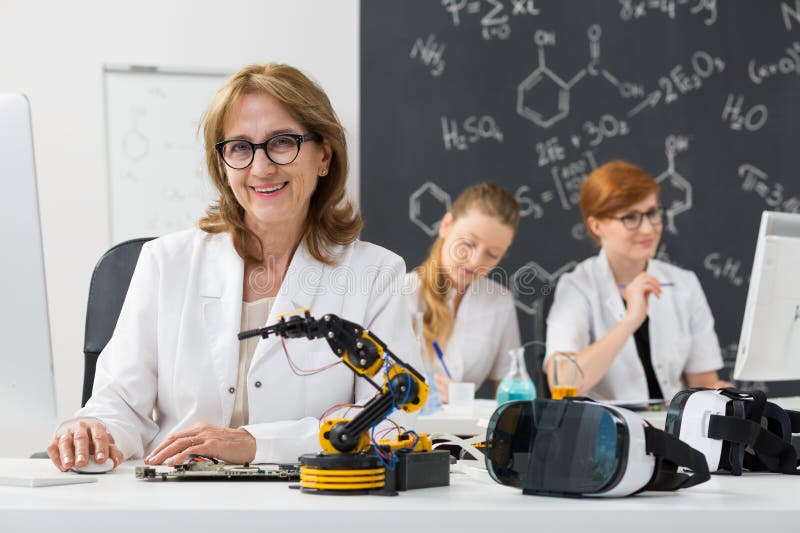 Smiling Professor Sitting in a Classroom Stock Photo - Image of ...