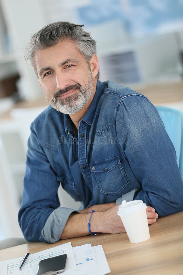 Smiling Professor Sitting at School Office Stock Photo - Image of ...