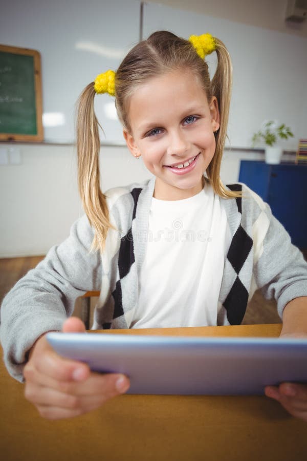 Smiling Pupil Using Tablet at Her Desk in a Classroom Stock Photo ...