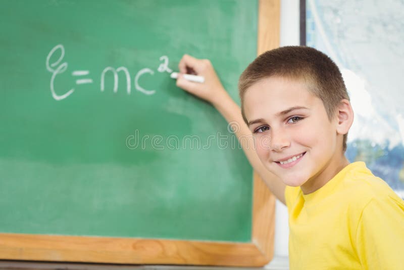 Smiling Pupil Writing on Chalkboard in a Classroom Stock Image - Image ...
