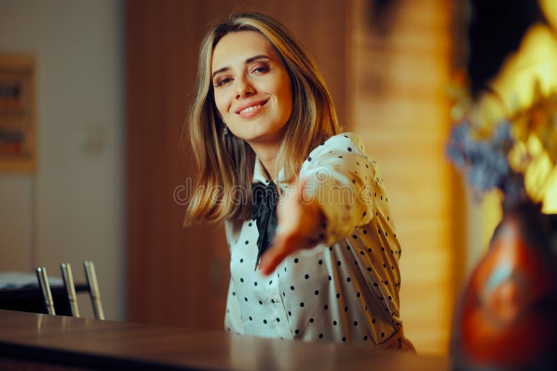 Smiling Receptionist Greeting with a Handshake at Her Desk Stock Photo ...